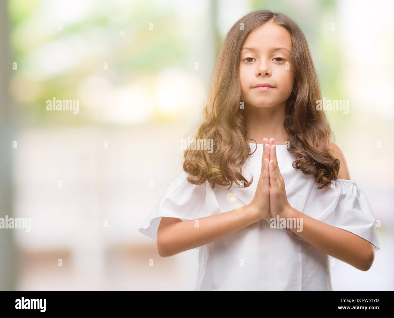 Brunette hispanic girl praying with hands together asking for ...