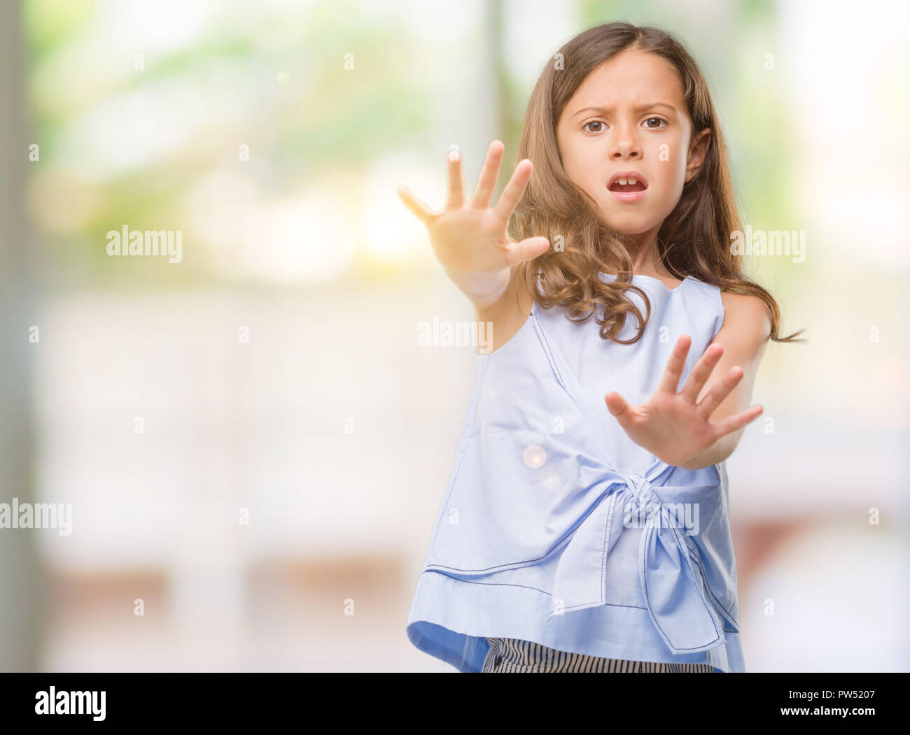 Brunette hispanic girl afraid and terrified with fear expression stop ...