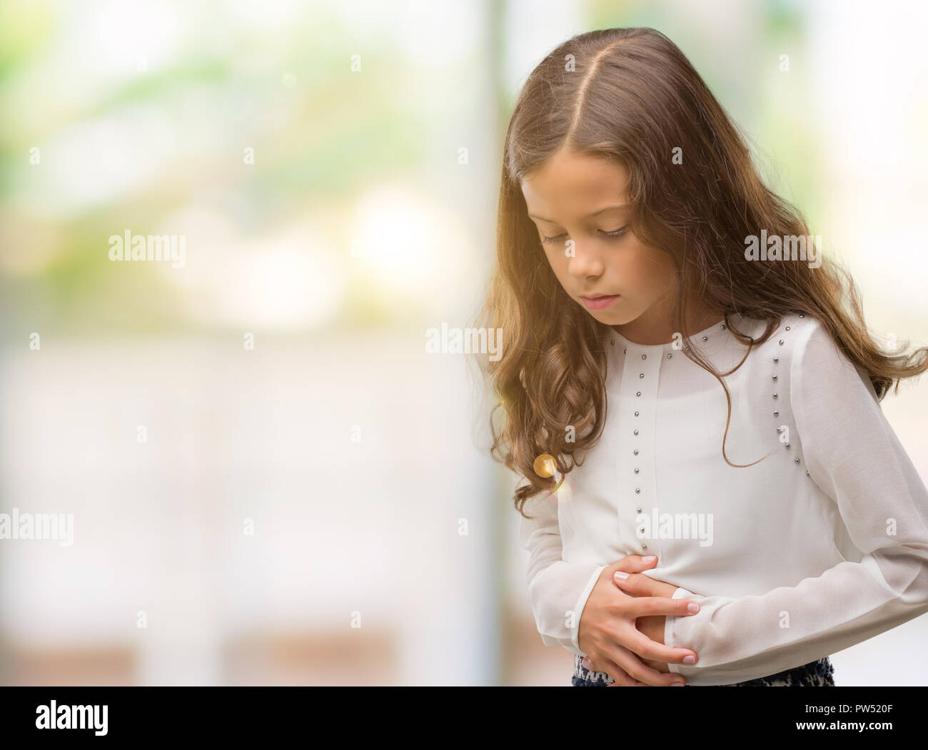 Brunette hispanic girl with hand on stomach because nausea, painful ...