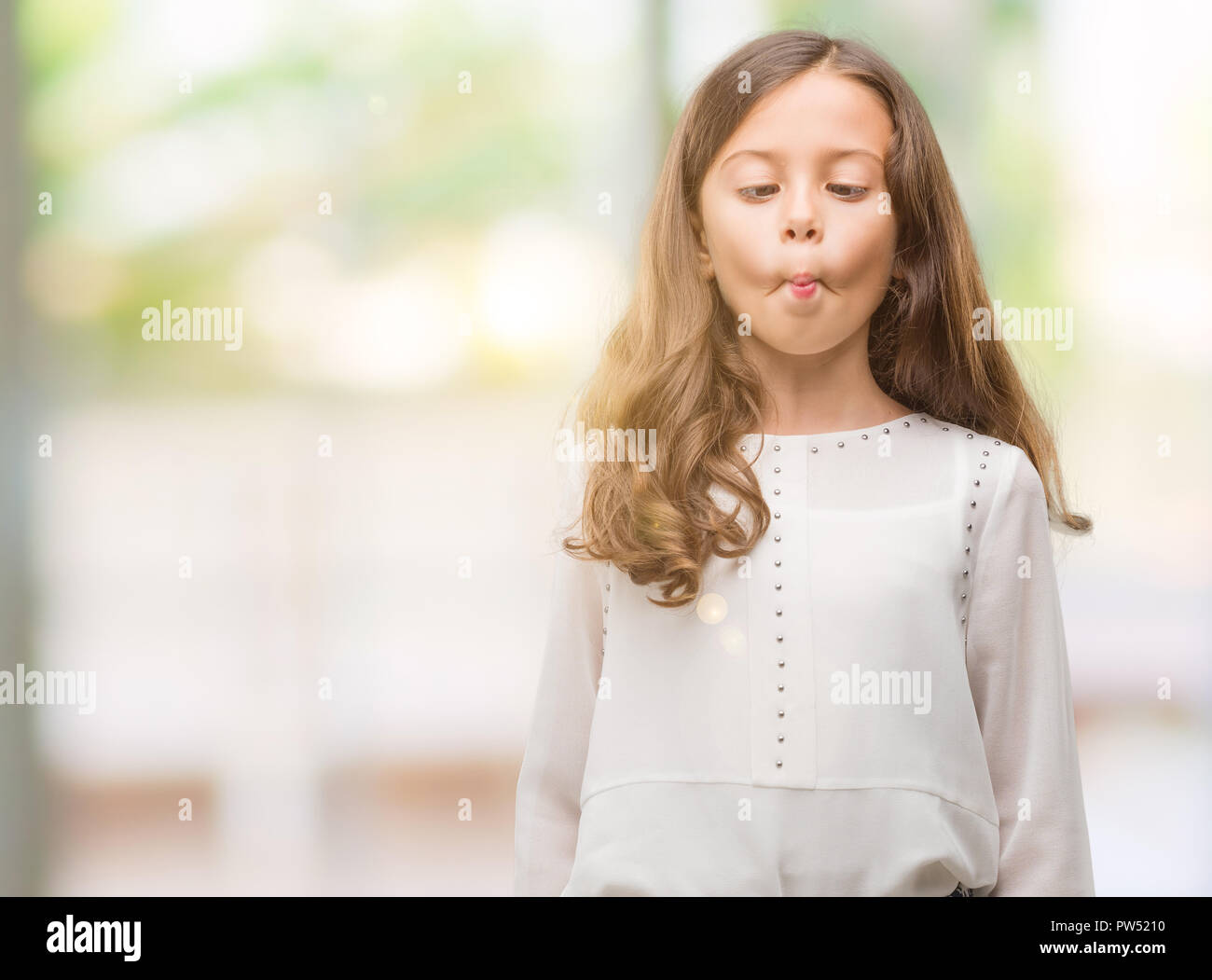 Brunette hispanic girl making fish face with lips, crazy and comical ...