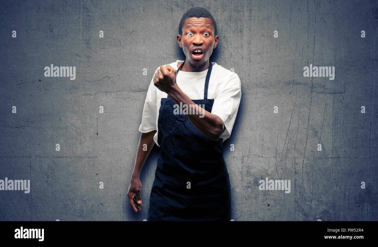 African man shop owner wearing apron irritated and angry expressing ...