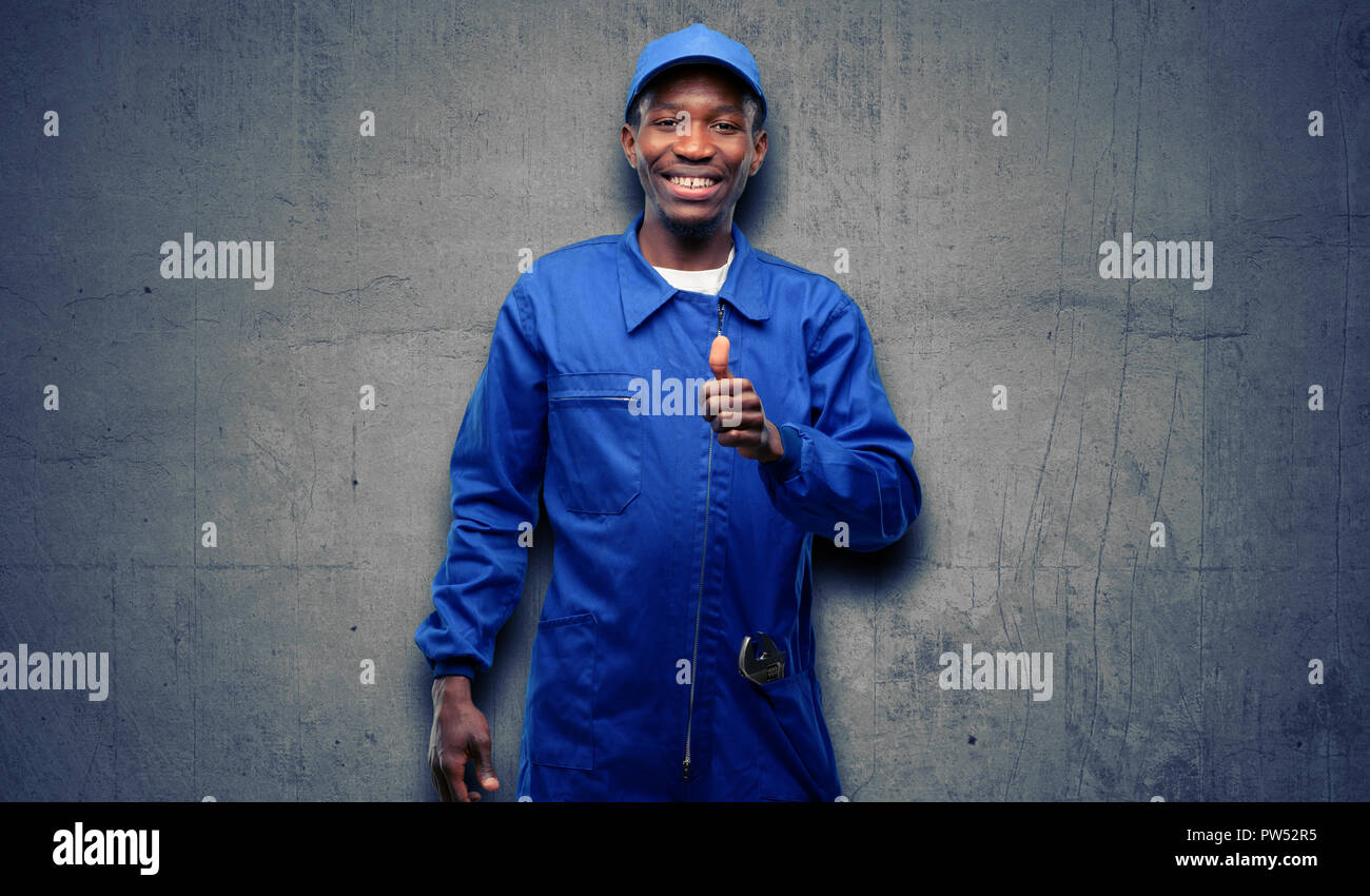 African black plumber man smiling broadly showing thumbs up gesture to ...