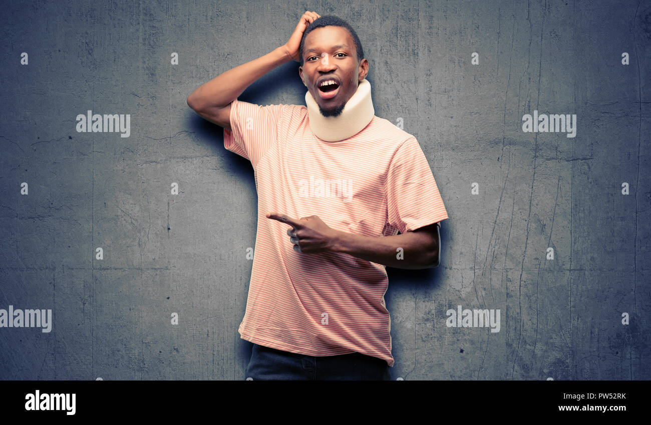 Injured african black man wearing neck brace pointing away side with ...