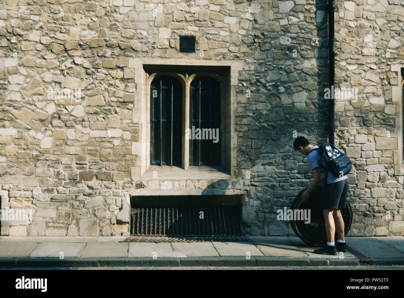 Guy moving a round table in Cambridge, rolling a heavy object Stock ...