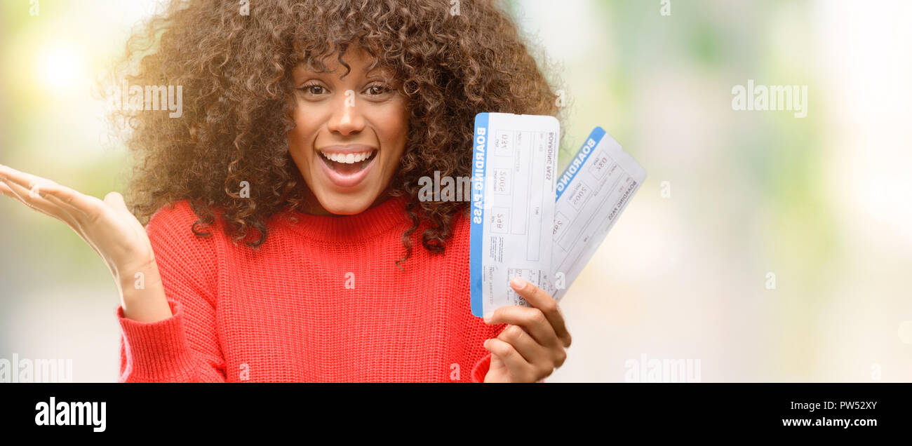 African american woman holding airline boarding pass tickets very happy ...