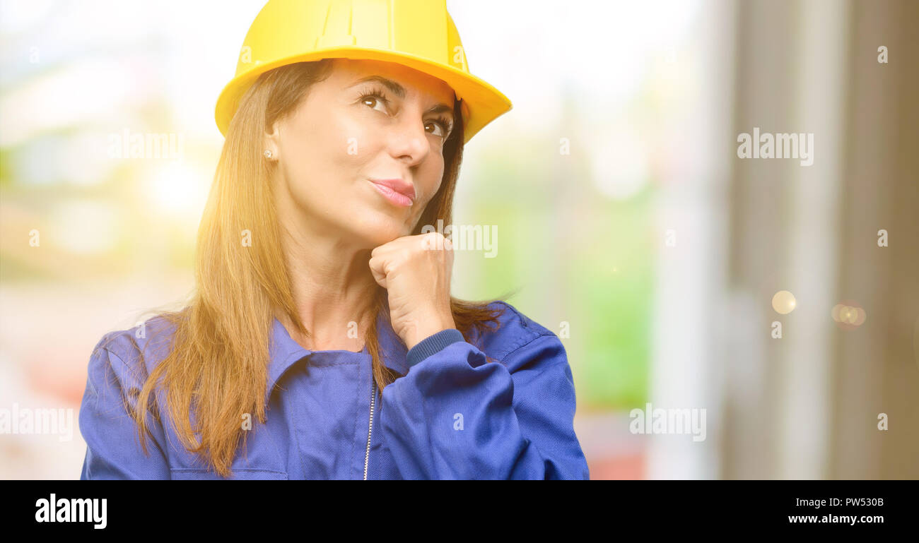 Engineer construction worker woman thinking and looking up expressing ...