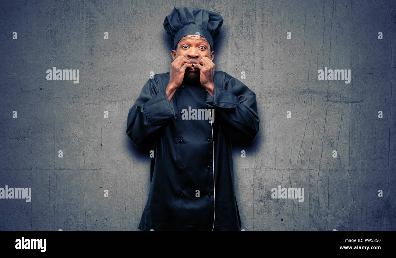 Young black cook wearing chef hat terrified and nervous expressing ...