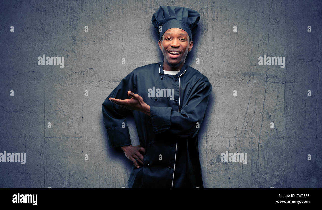 Young black cook wearing chef hat holding something in empty hand Stock ...