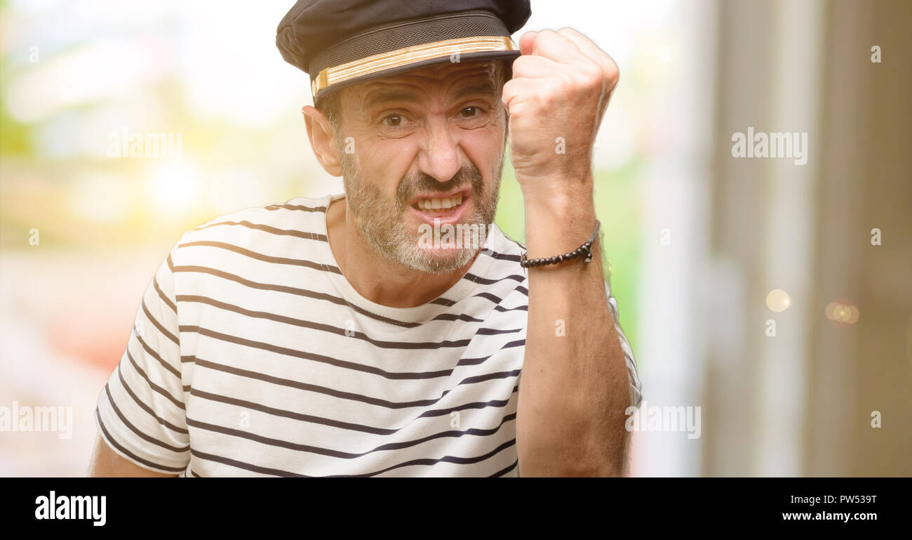 Sailor captain man smoking a tobacco pipe irritated and angry ...