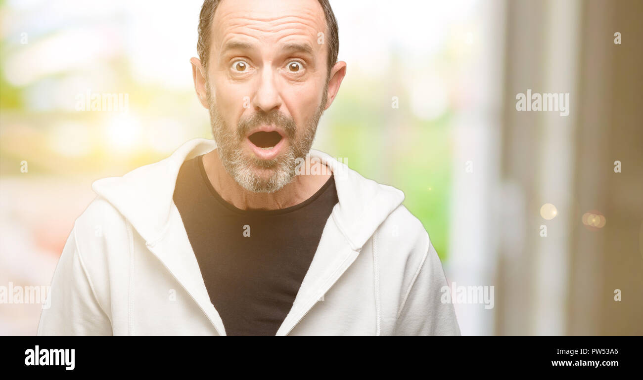 Middle age man wearing sportswear scared in shock, expressing panic and ...