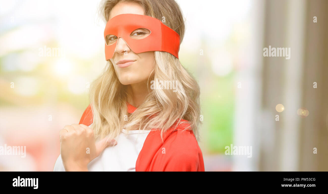Young super hero woman wearing cape proud, excited and arrogant ...