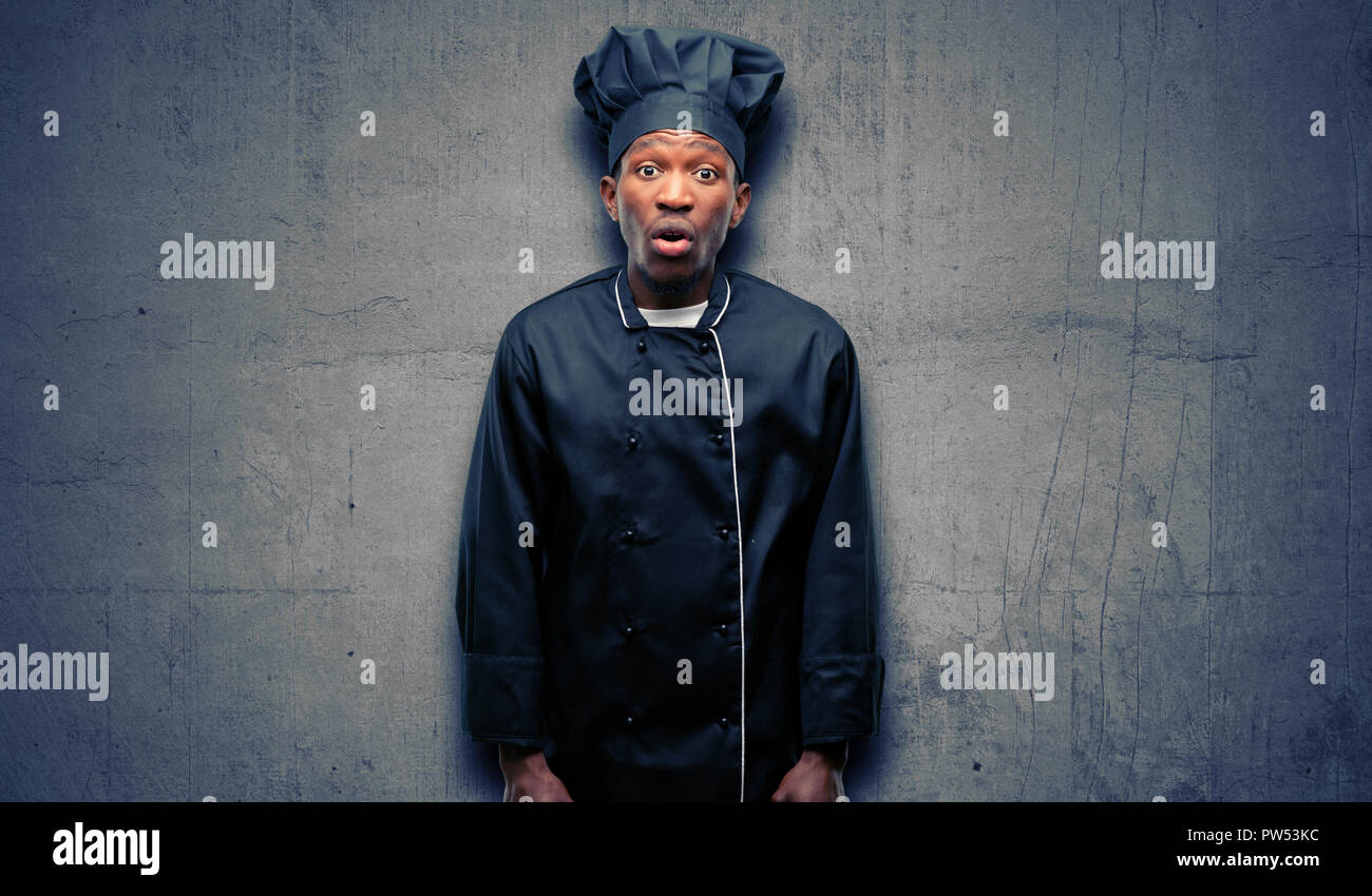 Young black cook wearing chef hat scared in shock, expressing panic and ...