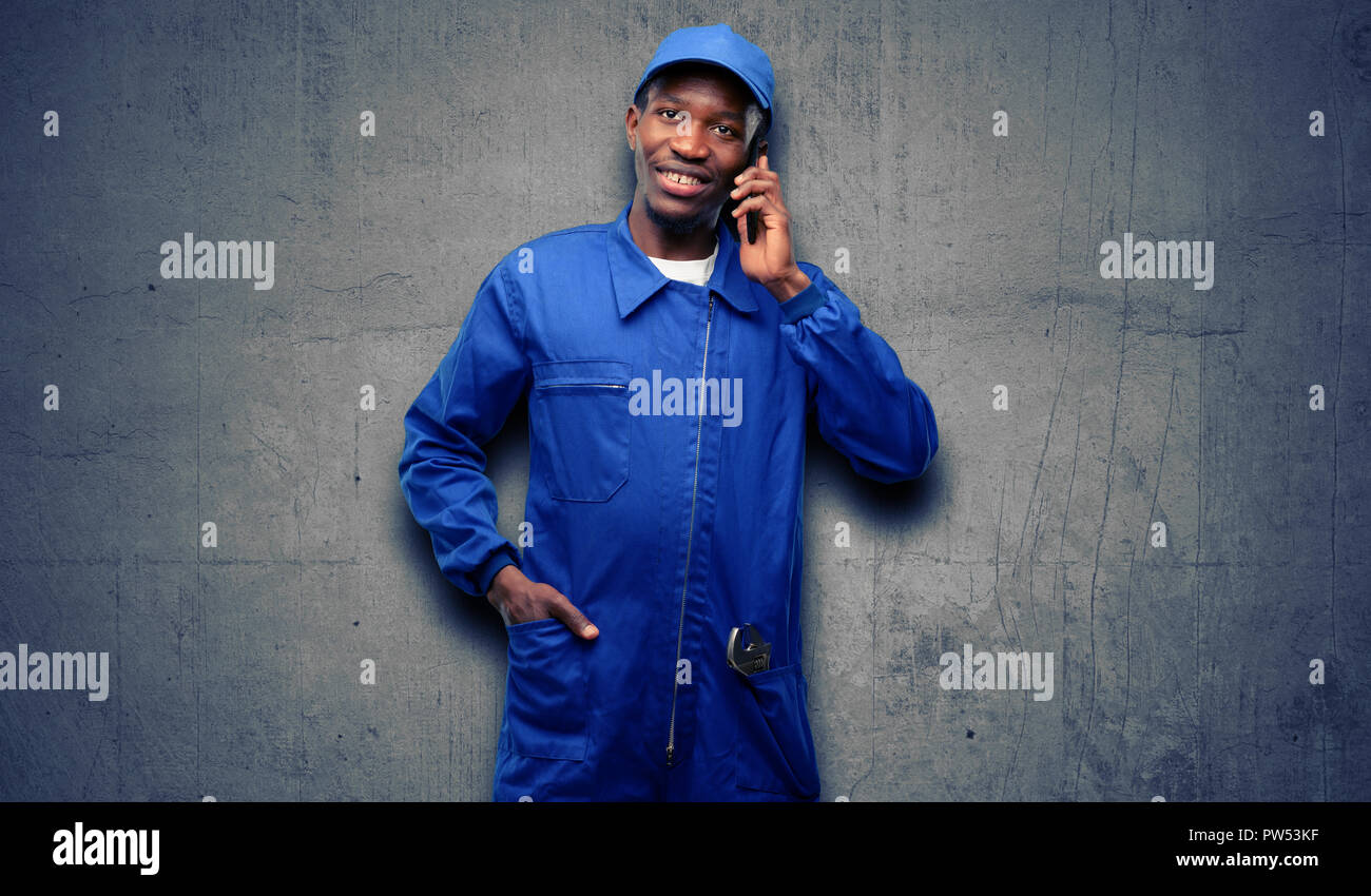 African black plumber man happy talking using a smartphone mobile phone ...