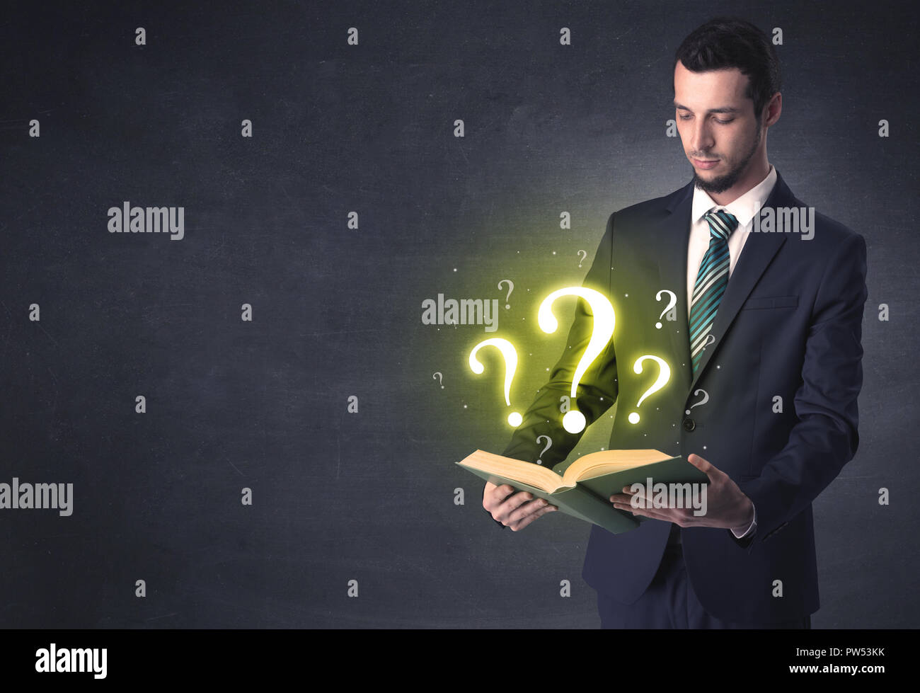 Businessman holding a book with question mark symbol Stock Photo - Alamy