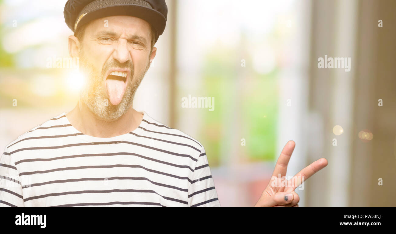 Sailor captain man smoking a tobacco pipe looking at camera showing ...