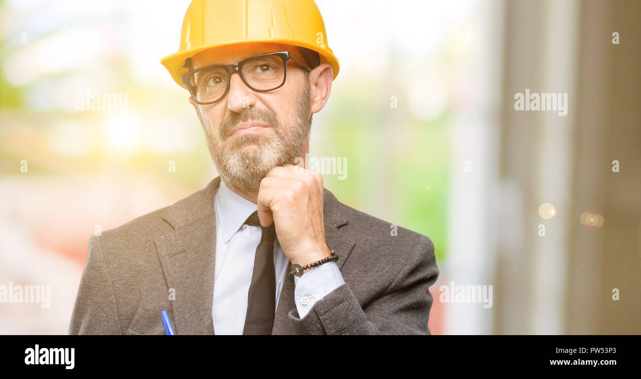 Senior architect or engineer thinking and looking up expressing doubt ...