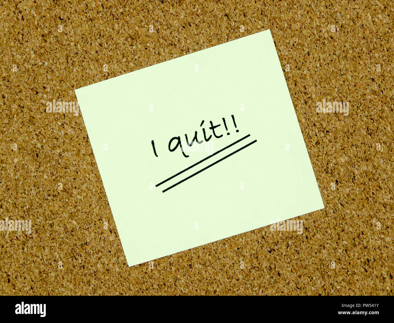 A yellow sticky note with I quit written on it on a cork board ...