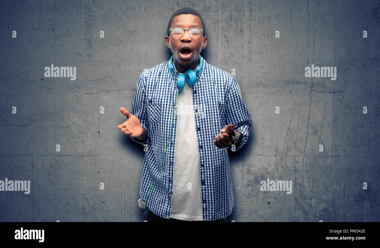 African black man student with smartphone scared in shock, expressing ...