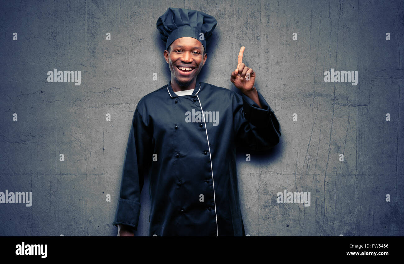 Young black cook wearing chef hat pointing away side with finger Stock ...