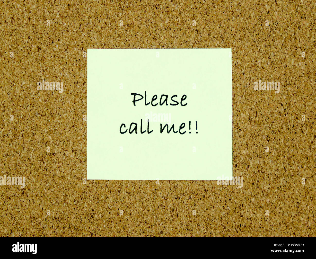 A yellow sticky note with please call me written on it on a cork board ...
