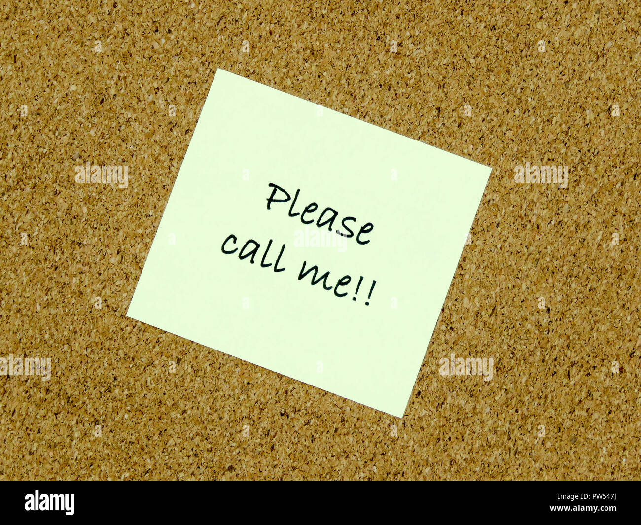 A yellow sticky note with please call me written on it on a cork board ...