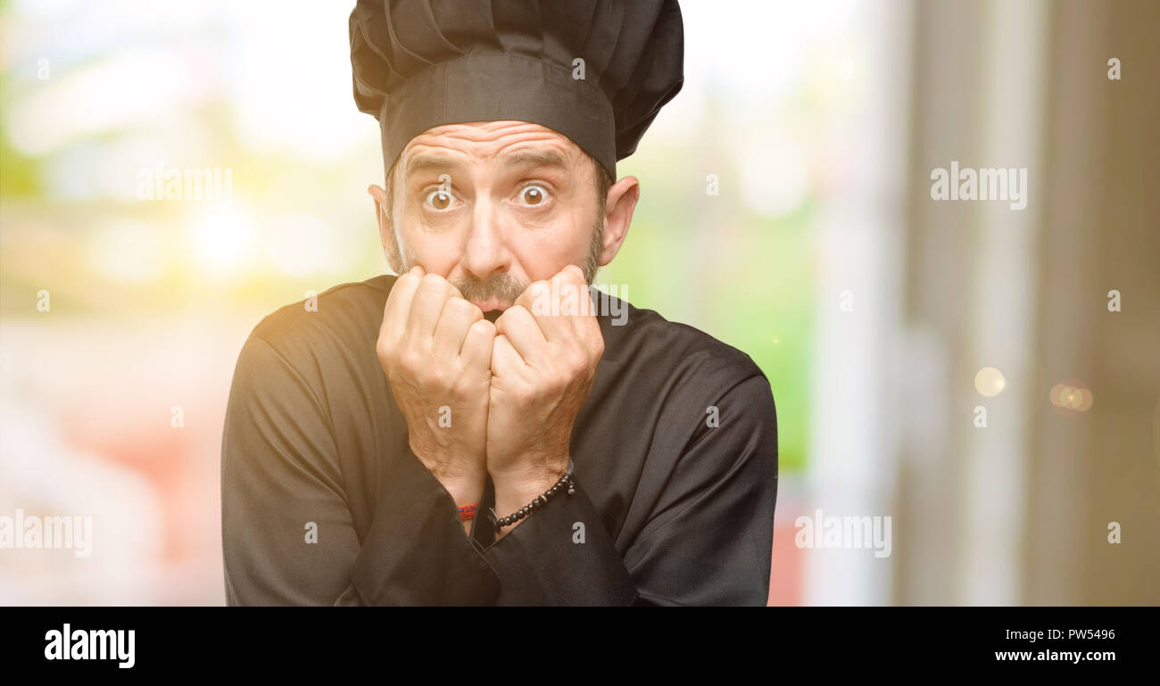Senior cook man, wearing chef hat terrified and nervous expressing ...