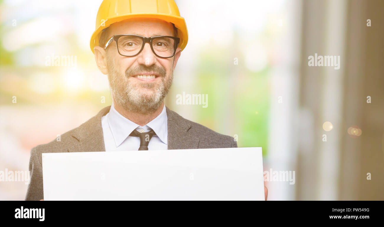 Senior architect or engineer holding blank advertising banner, good ...
