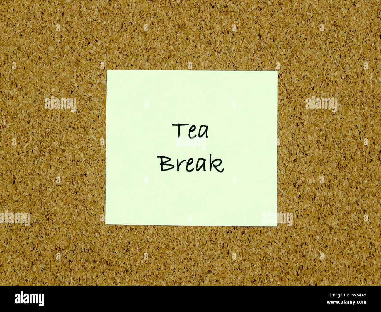 A yellow sticky note with tea break written on it on a cork board ...