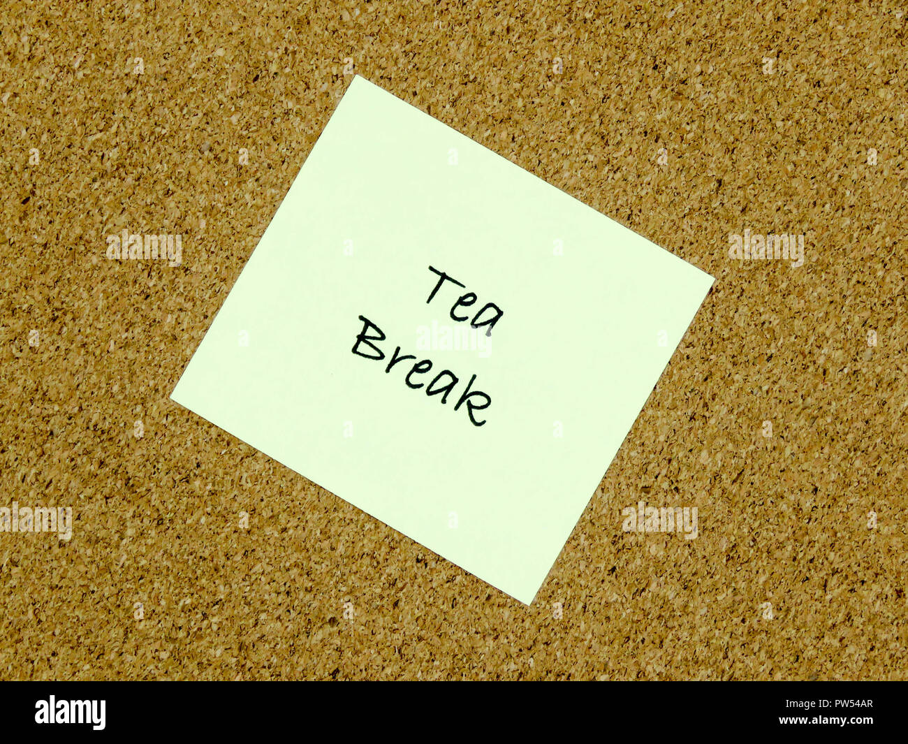A yellow sticky note with tea break written on it on a cork board ...