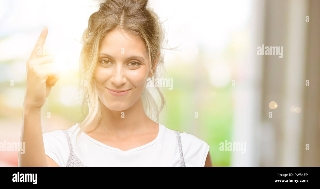 Young beautiful woman raising finger, the number one Stock Photo - Alamy