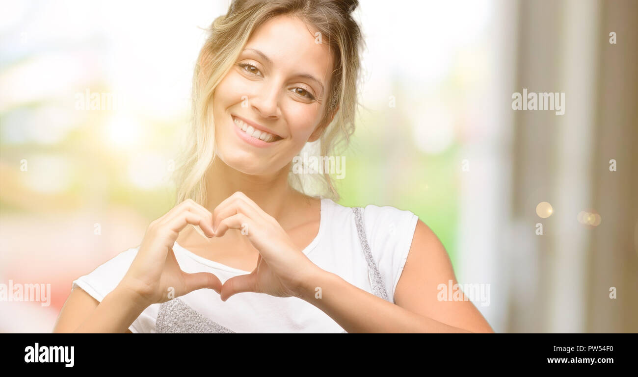 Young beautiful woman happy showing love with hands in heart shape ...