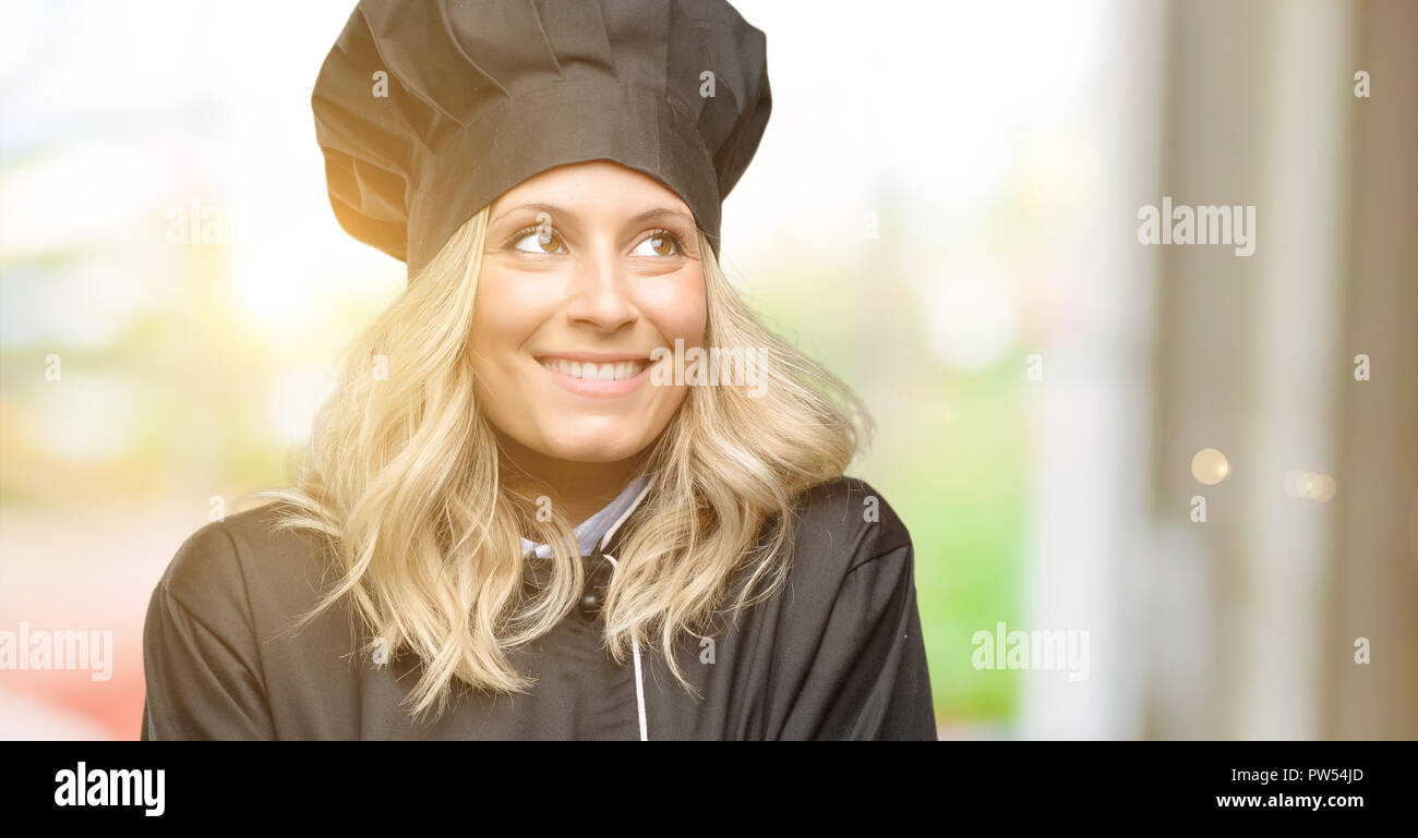 Beautiful cook woman chef thinking and looking up expressing doubt and ...