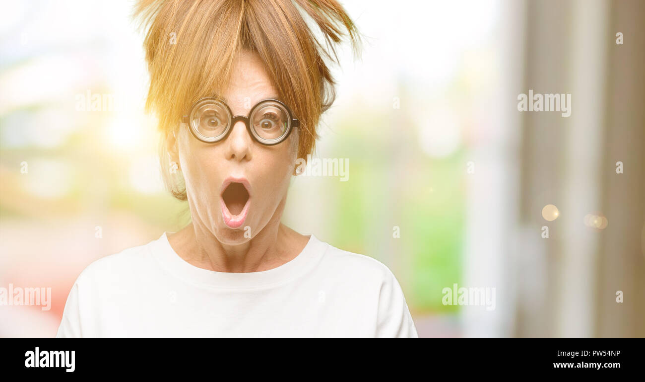 Crazy middle age woman wearing silly glasses scared in shock ...