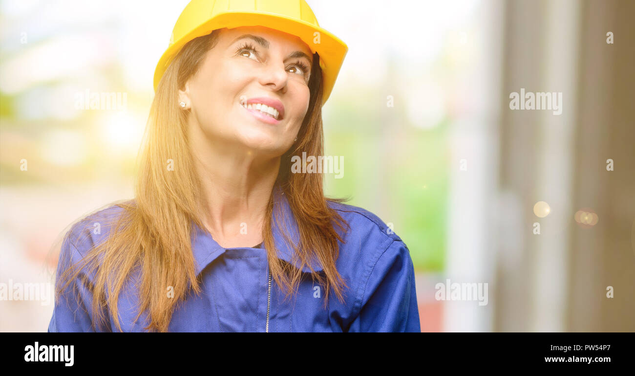 Engineer construction worker woman thinking and looking up expressing ...