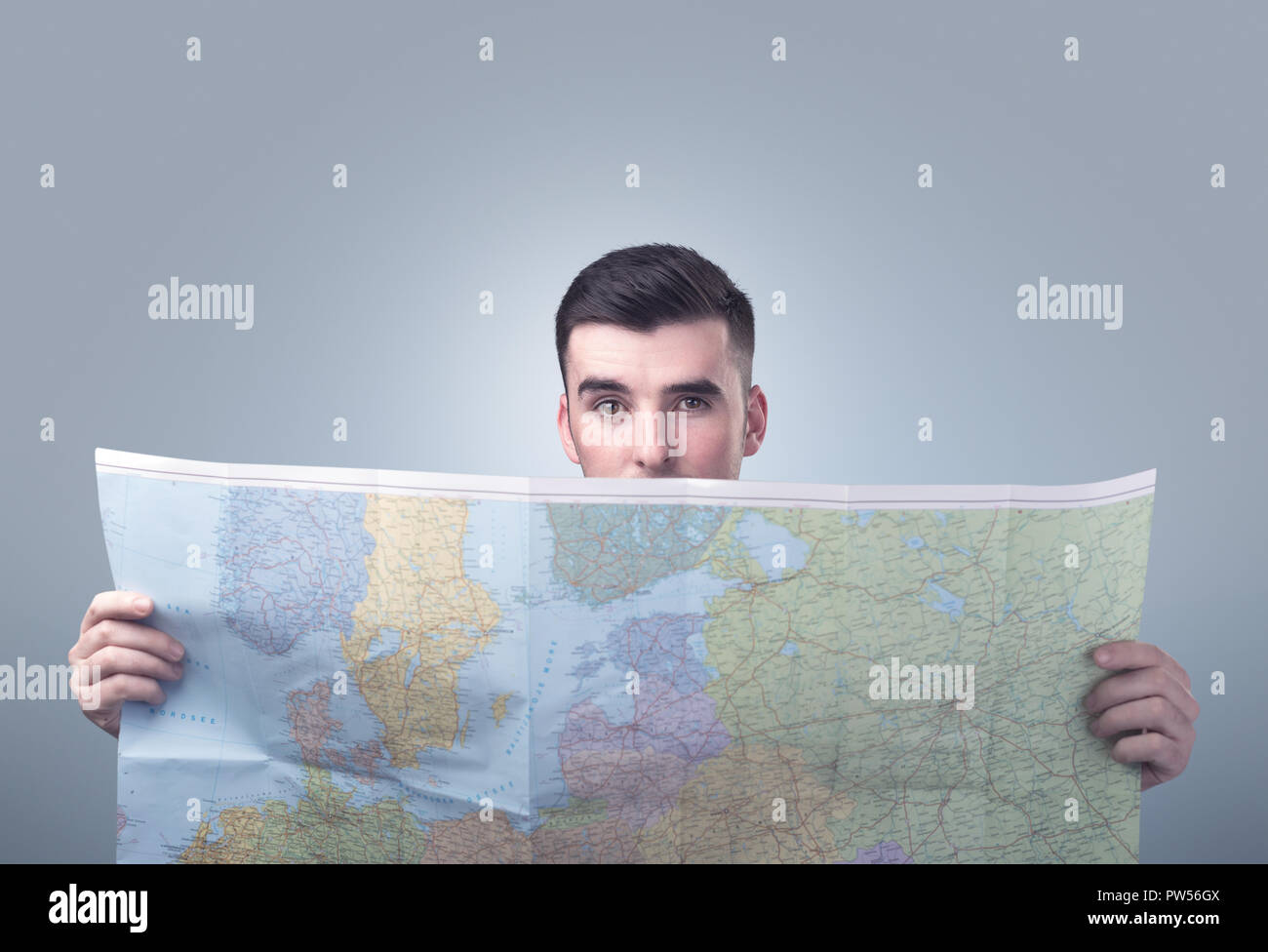 Handsome young man holding map Stock Photo - Alamy