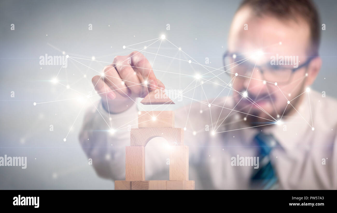 Young handsome businessman using wooden building blocks with ...