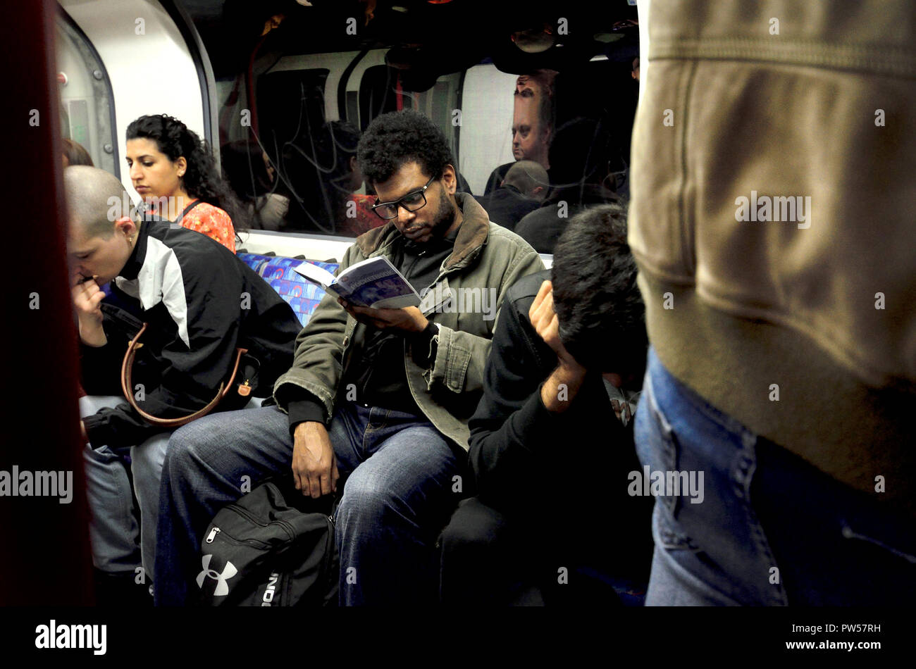 Reading a book on a London Underground tube train, London, England, UK ...
