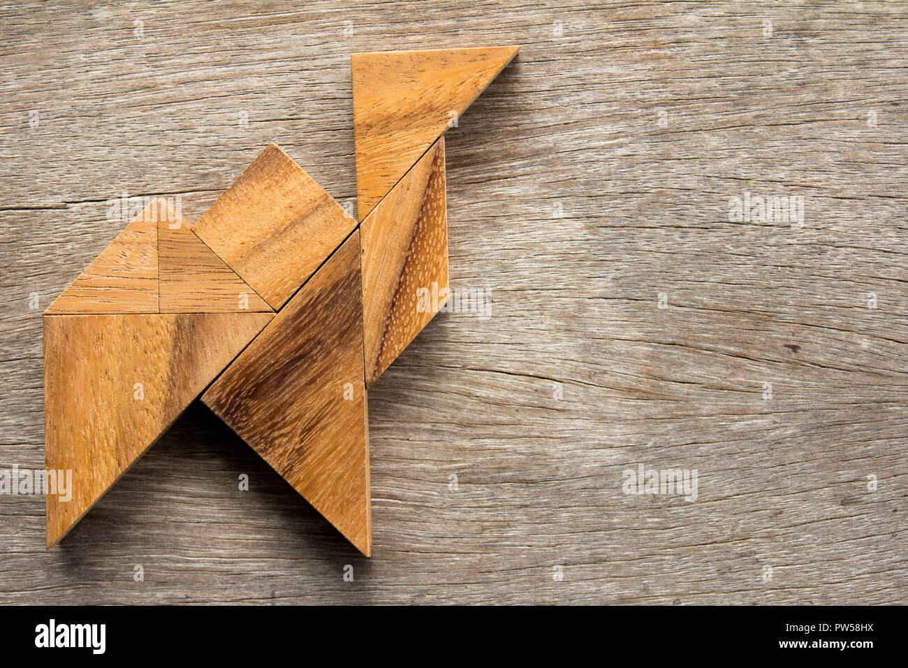 Chinese tangram puzzle in walking camel shape on wooden background ...