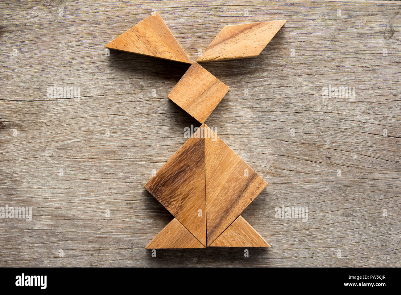 Chinese tangram puzzle in rabbit shape on wooden background (Concept ...