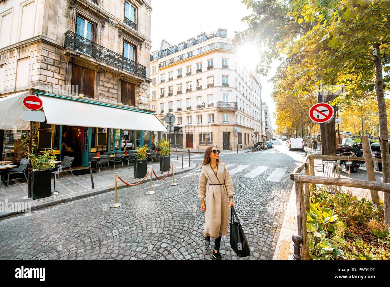 Morning street view with stylish woman crossing the street in Paris ...