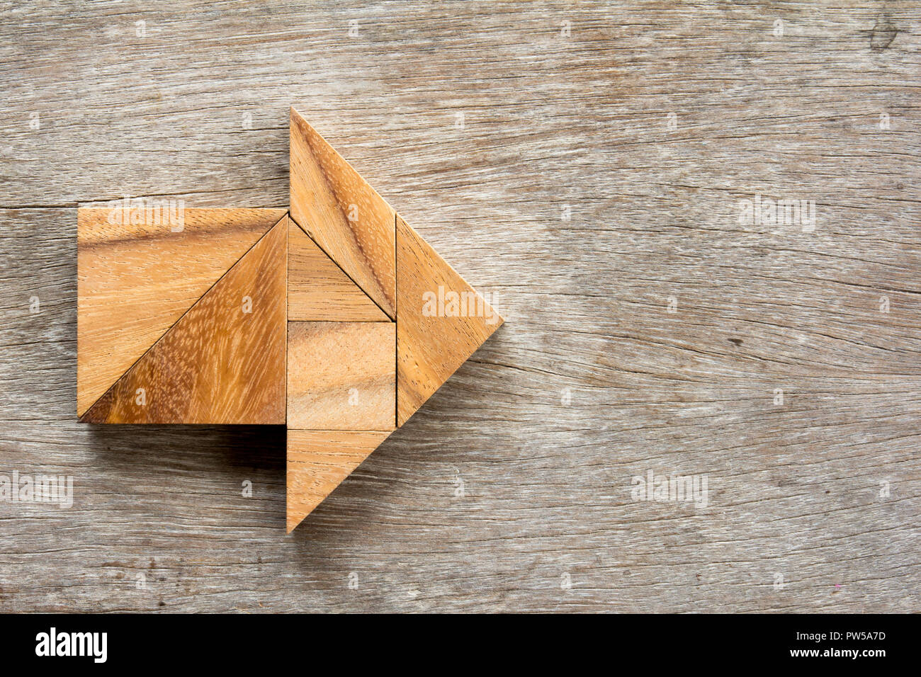 Tangram puzzle in arrow shape on wooden background Stock Photo - Alamy