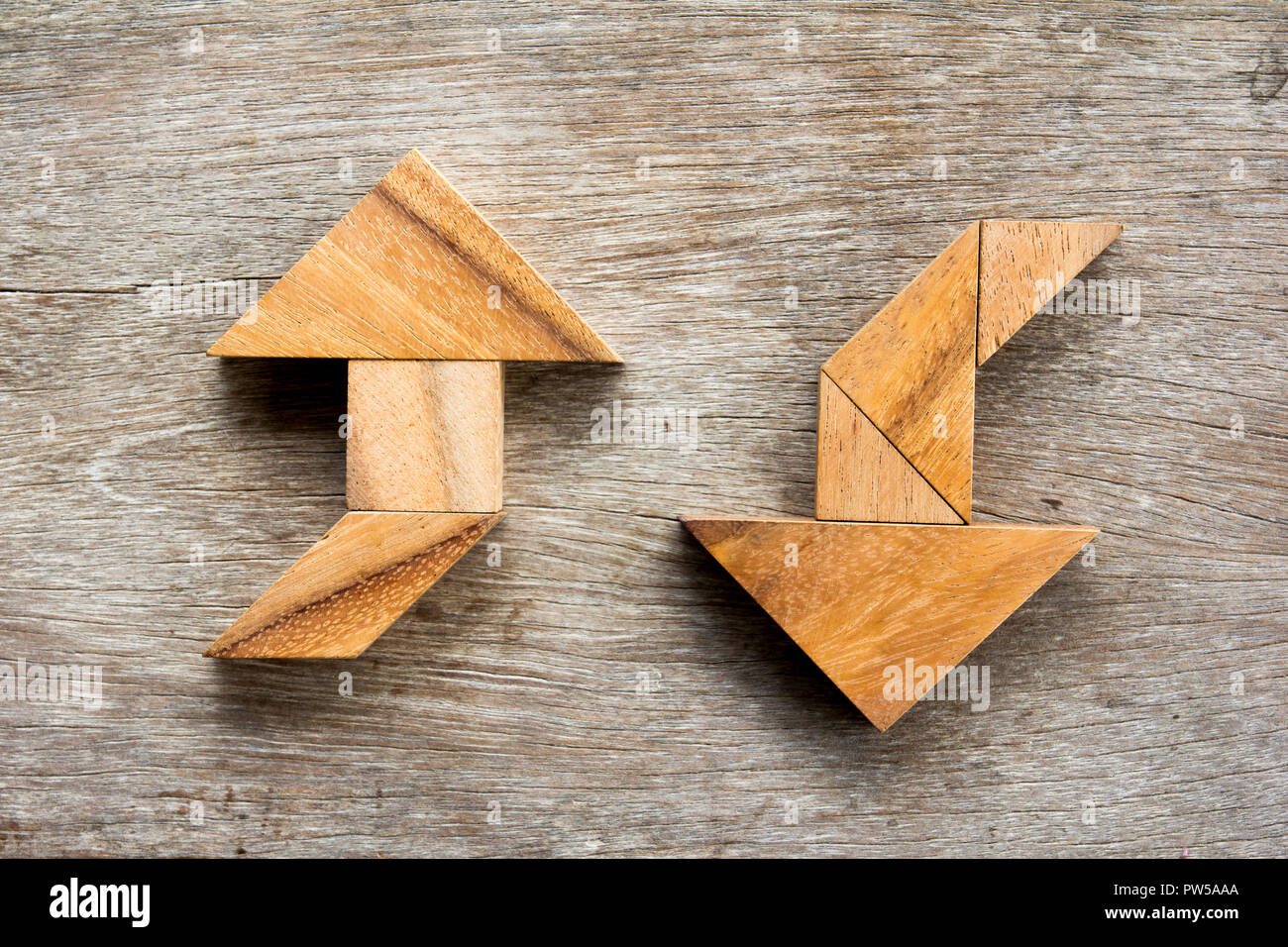 Tangram puzzle as two way arrow shape on wooden background Stock Photo ...