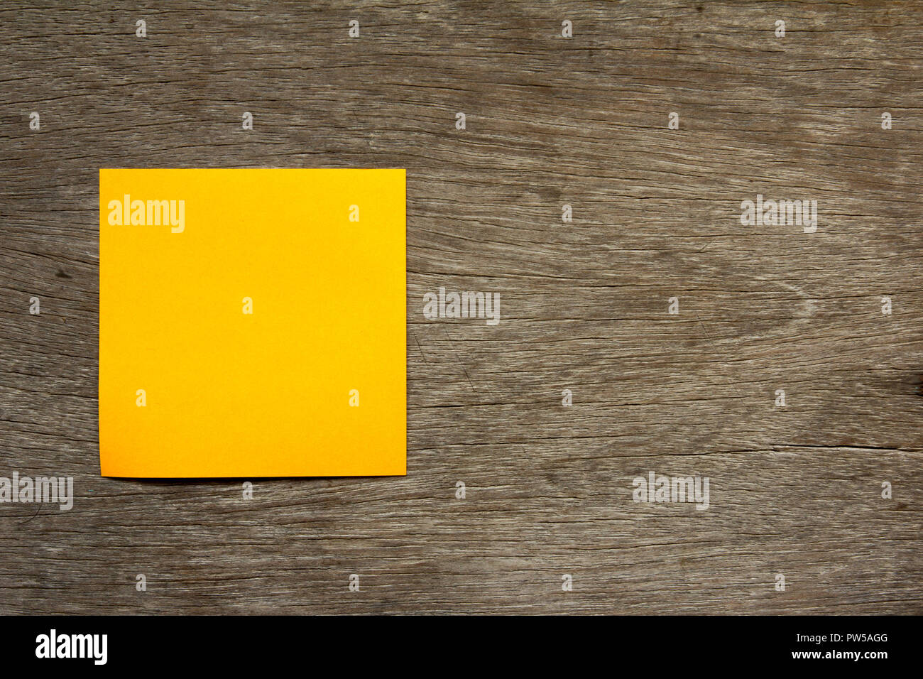 Blank orange note paper attach on brown wooden background for memo or ...