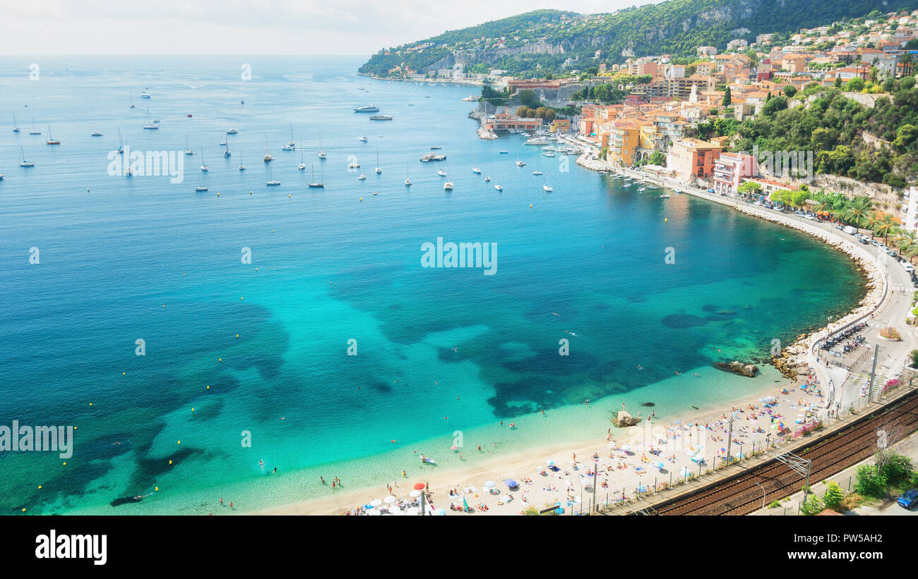 Bathers enjoy at the beach of the beautiful bay of Villefranche-sur-Mer ...