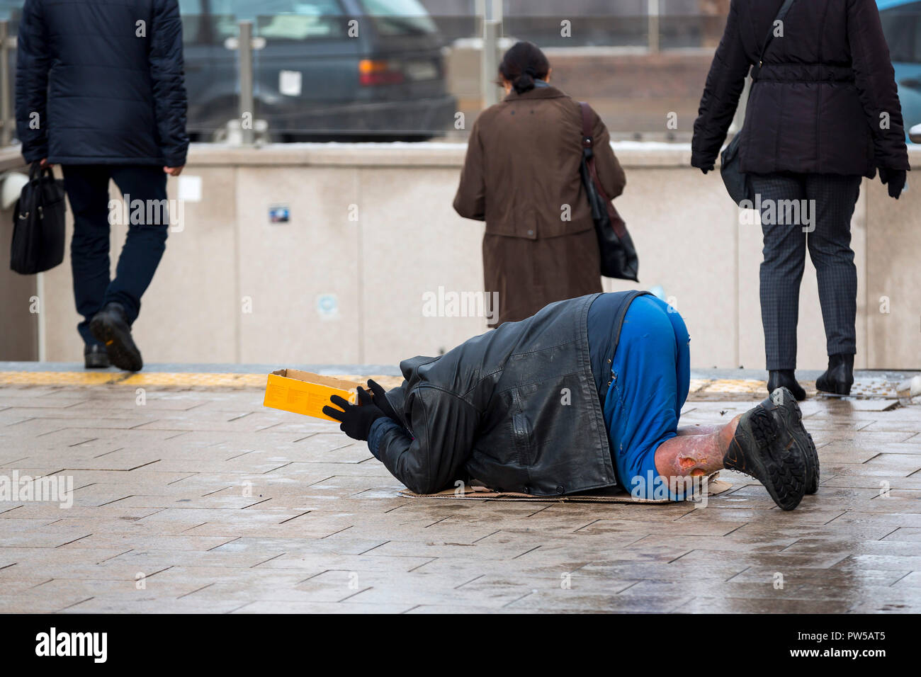 Homeless man with hurt leg on his knees begs for money at the street. Ten years after joining ...