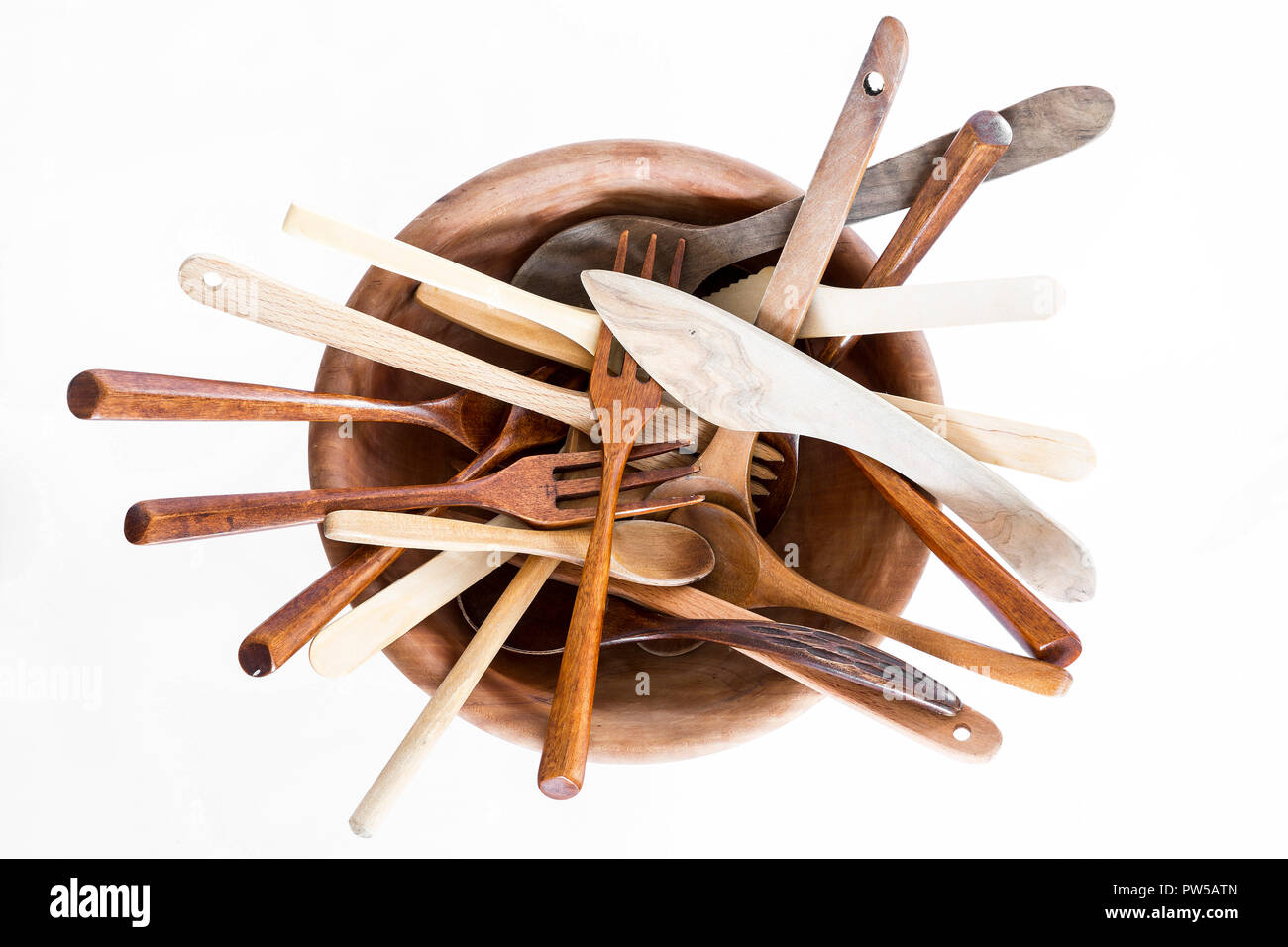 Wooden bowl with spoons and forks on a white background. Studio shot ...