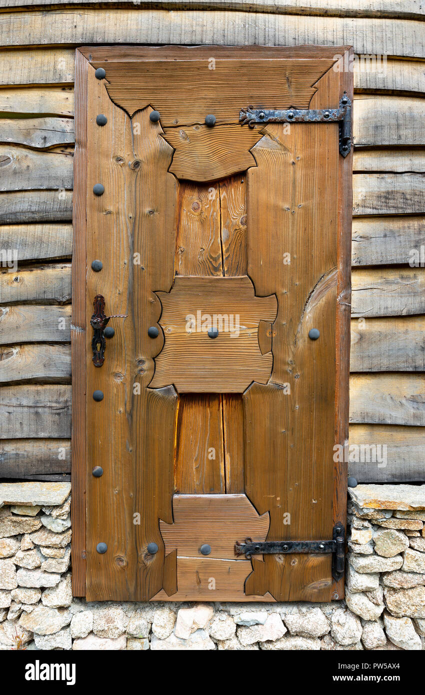 Old wooden door of a hut with wooden walls and base of rocks Stock ...