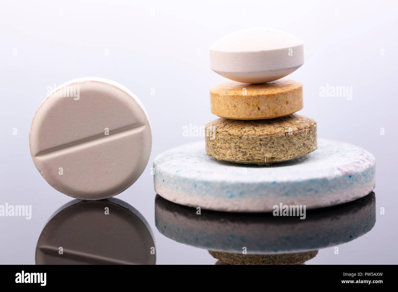 Multiple capsules and pills isolated on black reflective surface ...