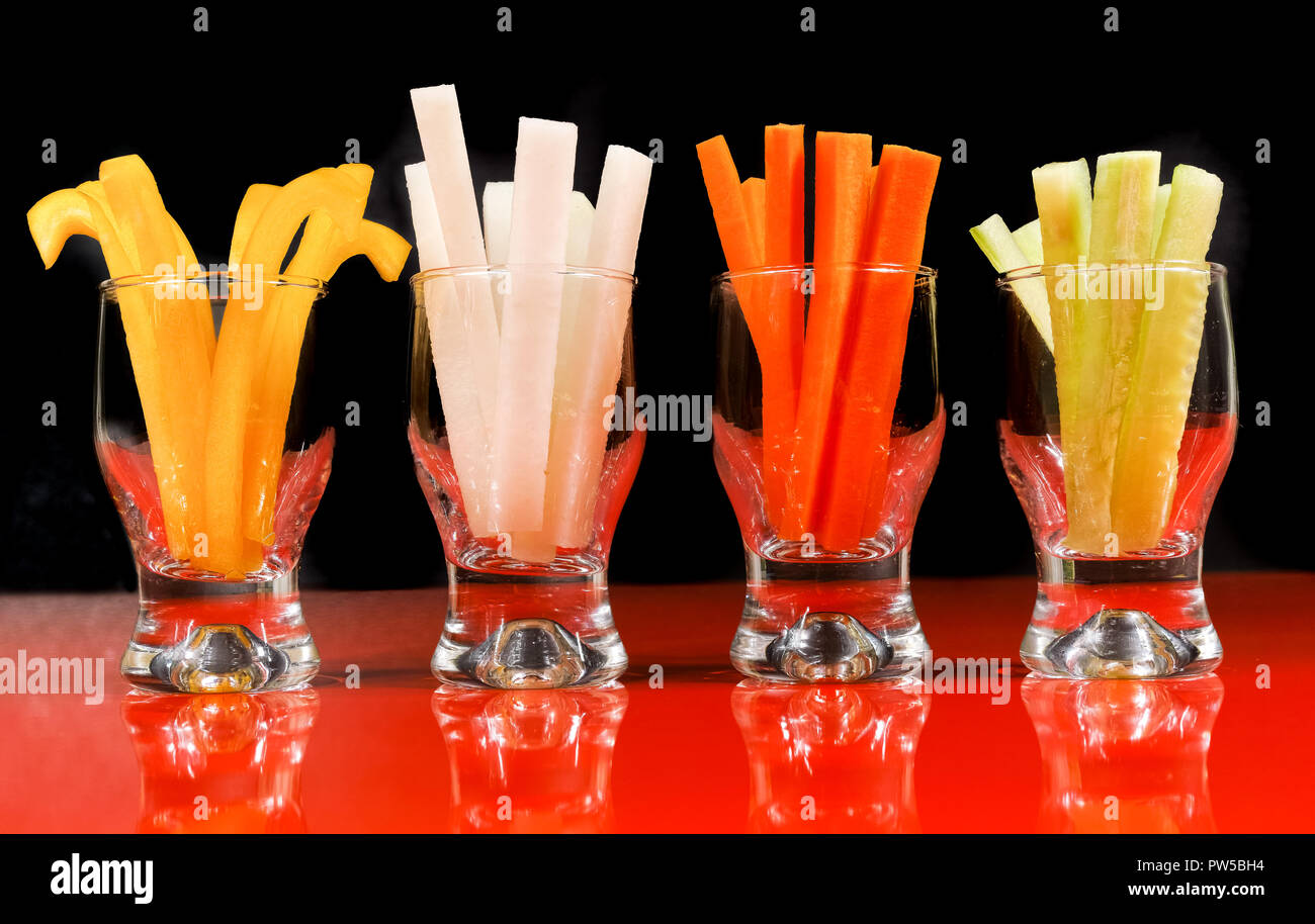 Four types of vegetable sticks, healthy finger food served on red table ...