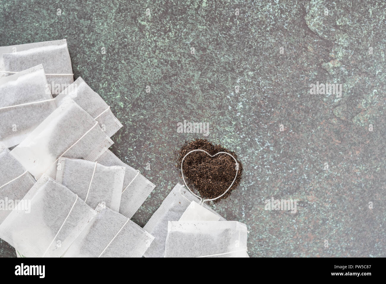 pile of teabags with the string of one forming a heart around loose tea ...